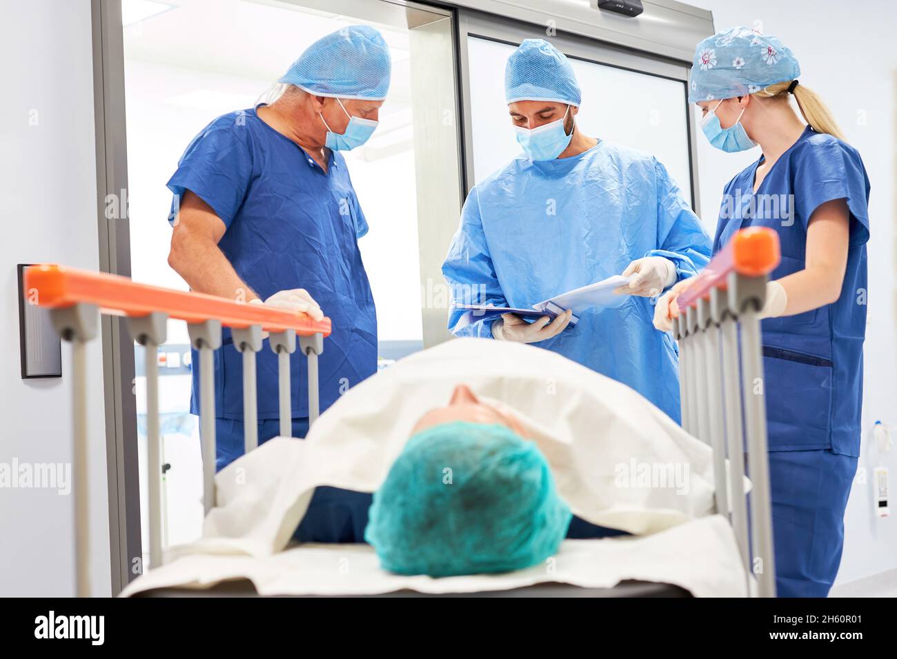 Group of doctors and nurse with patient before surgery in a clinic ...