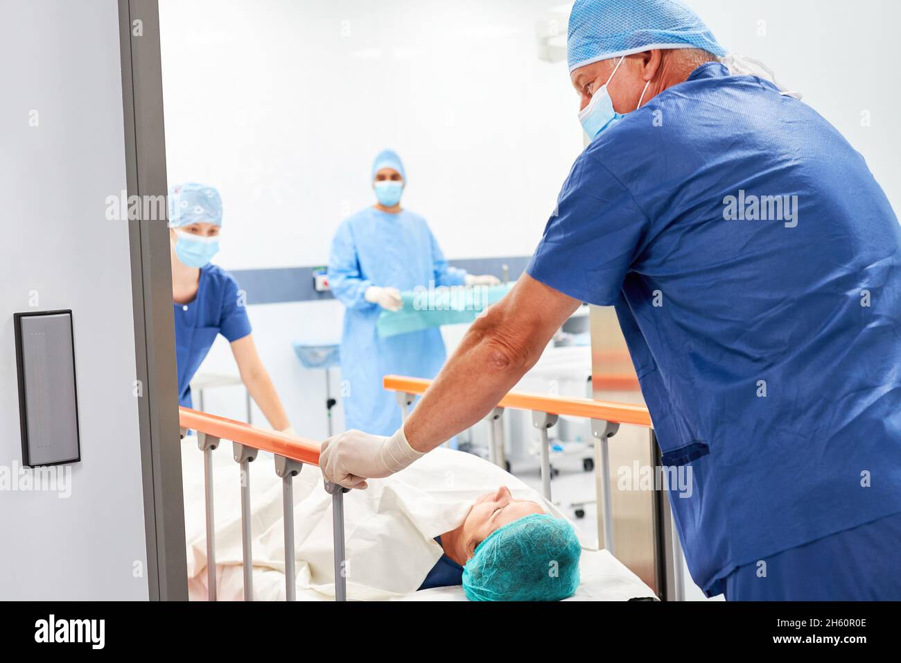 Two nurses push the patient in the hospital bed into the surgery ...