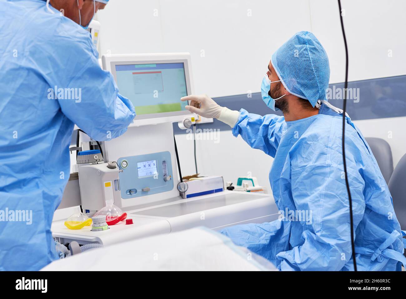 The surgeon and anesthetist check the patient on the surveillance ...