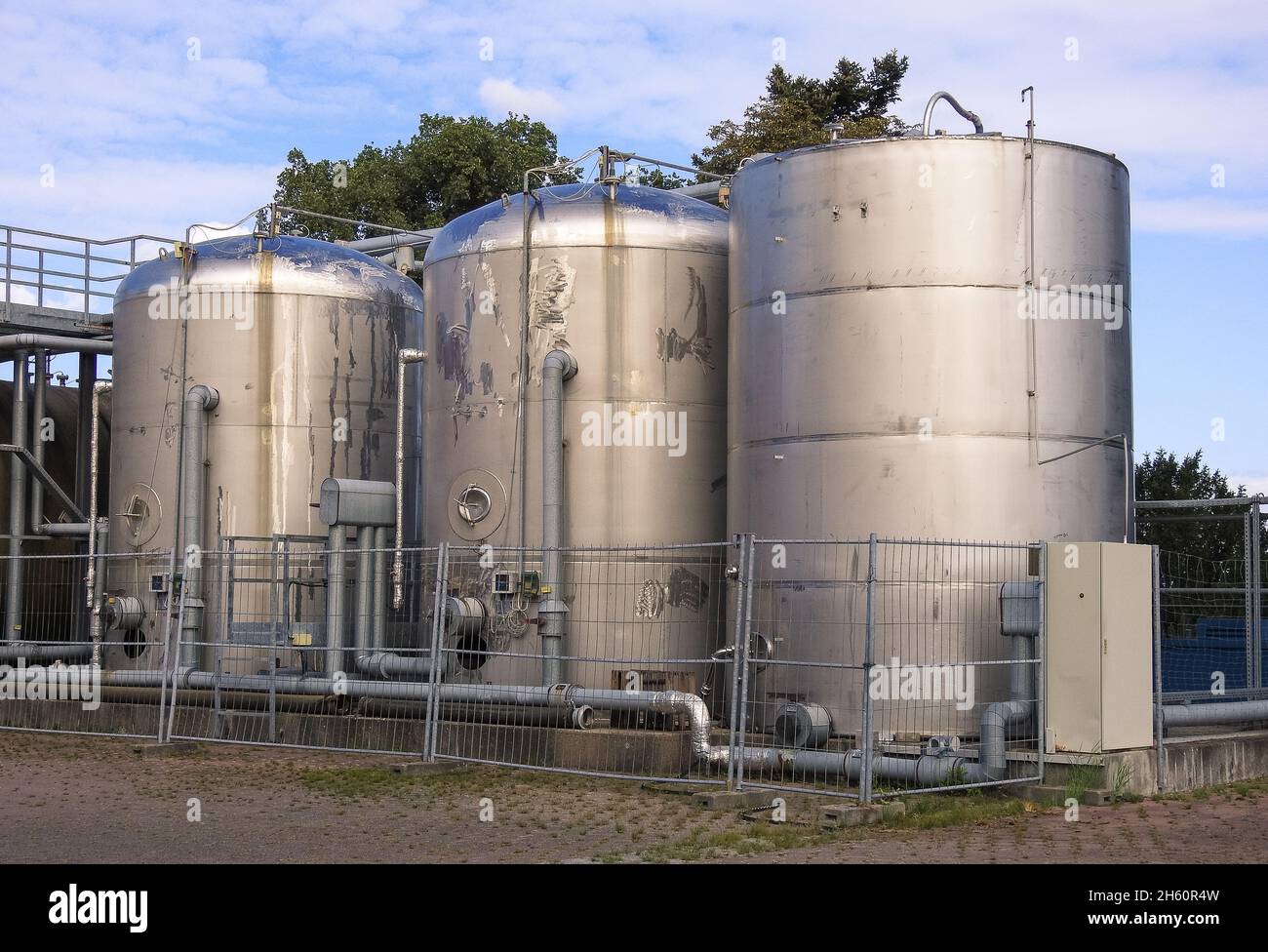 Metal fence around an industrial facility with tanks andpipes Stock ...
