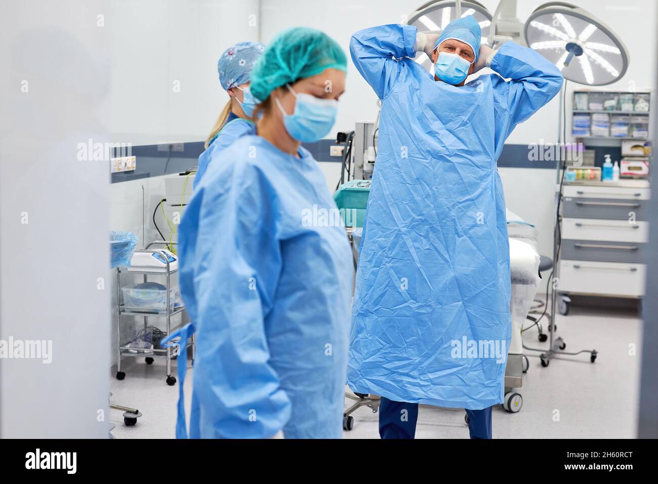 Group of doctors and operating room nurses stand tired and exhausted in ...