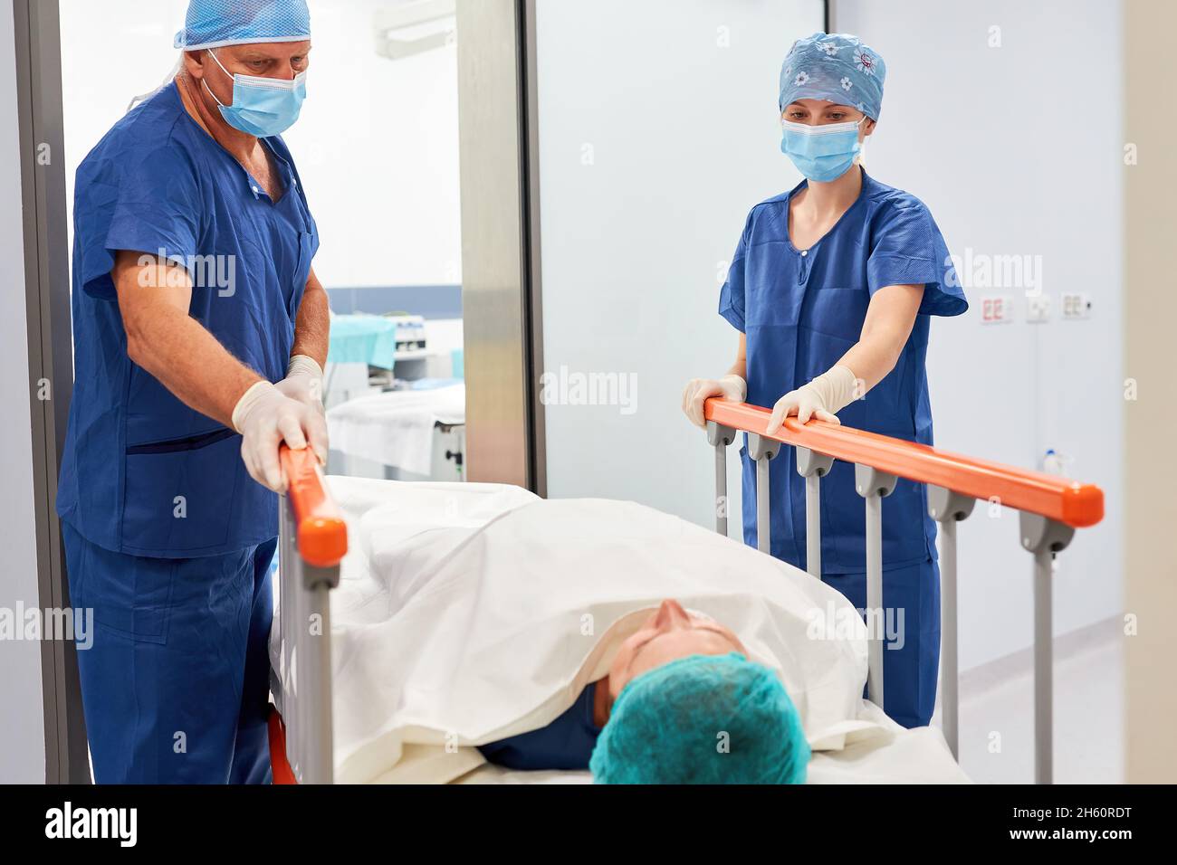 The surgeon and the operating room nurse take care of the patient in ...