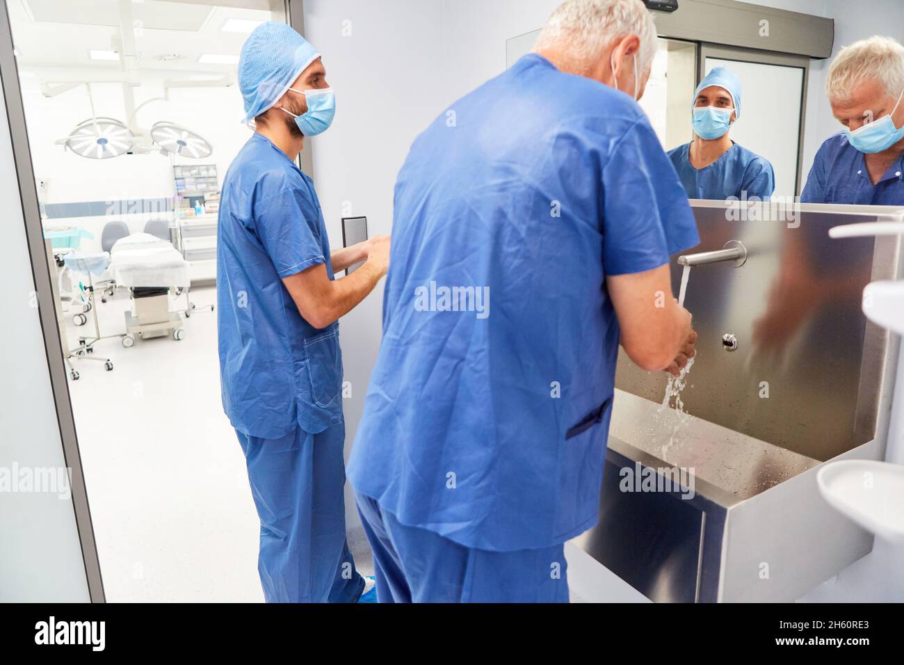 Surgeons team washing their hands for disinfection at the sink in front ...