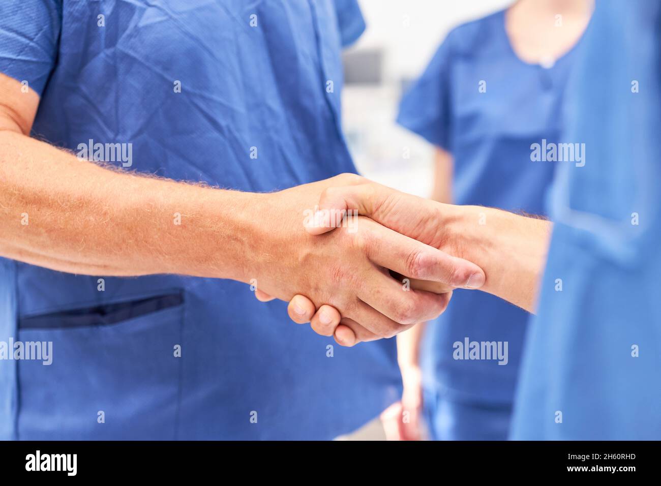 Doctors in the operating room shaking hands before the operation as a ...