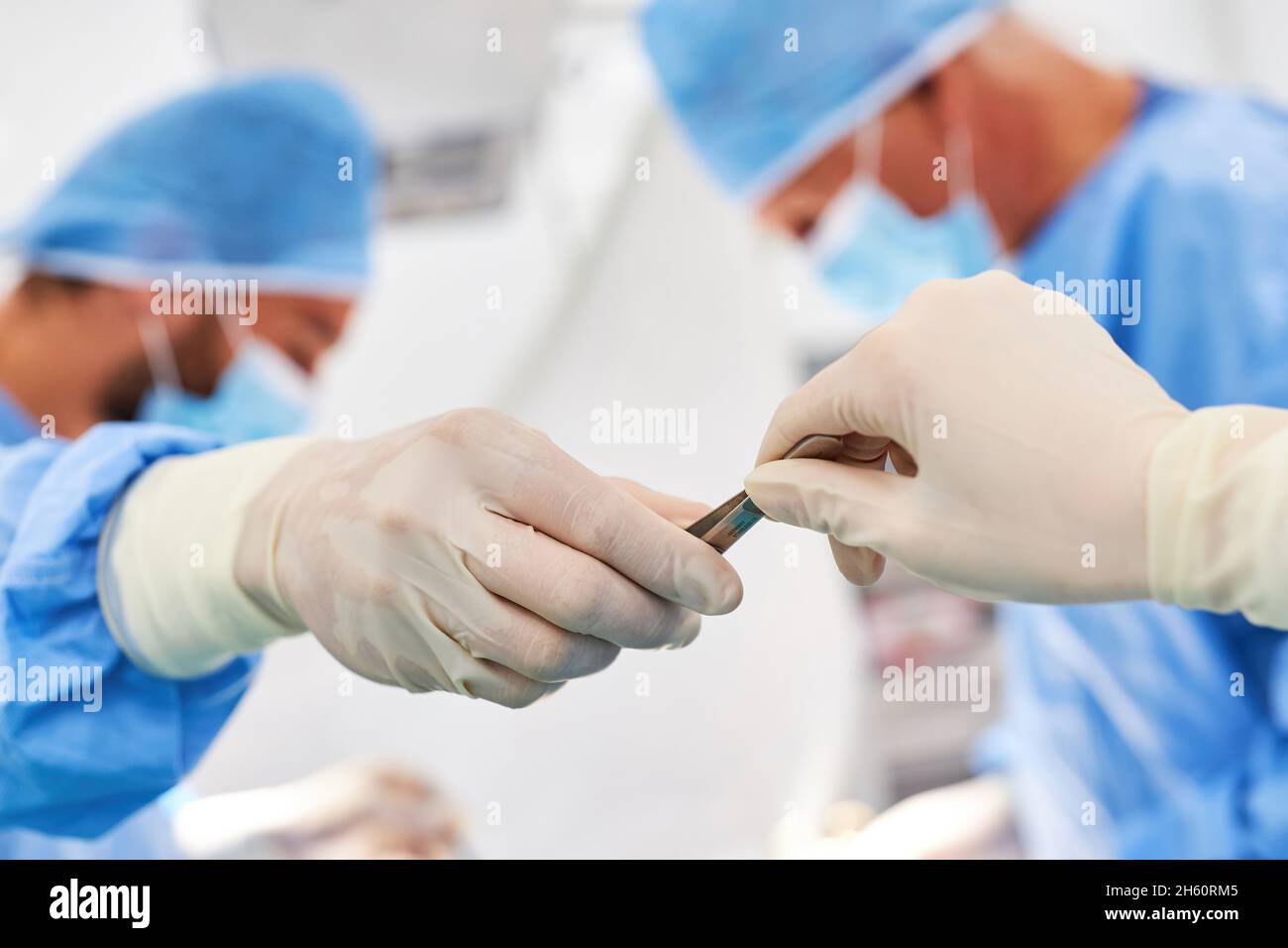 Surgeon assists a procedure in the emergency room and hands over a ...
