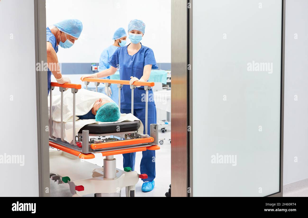 Doctor talks to patient in hospital bed before surgery in emergency ...