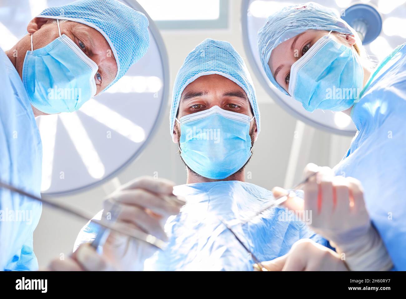 Doctors team in surgery during operation over patient during surgical ...