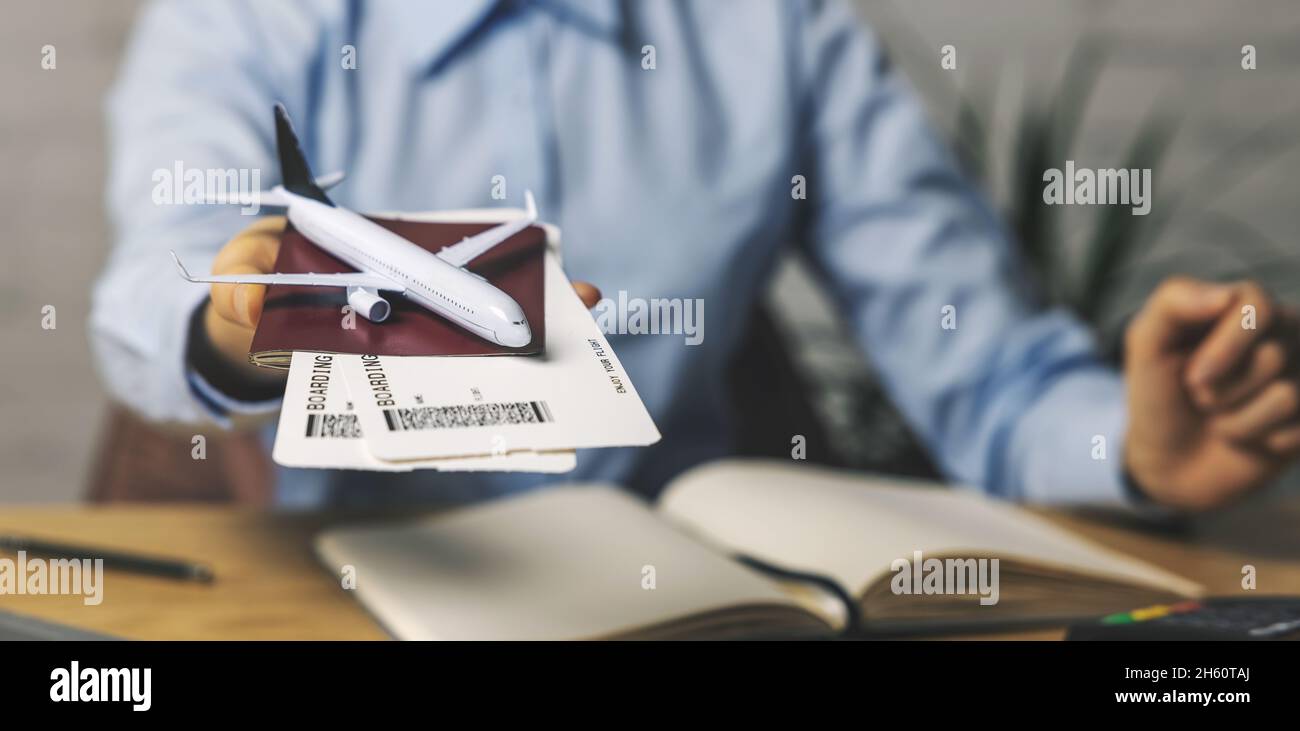 travel agent with flight tickets and plane model in hand at agency ...