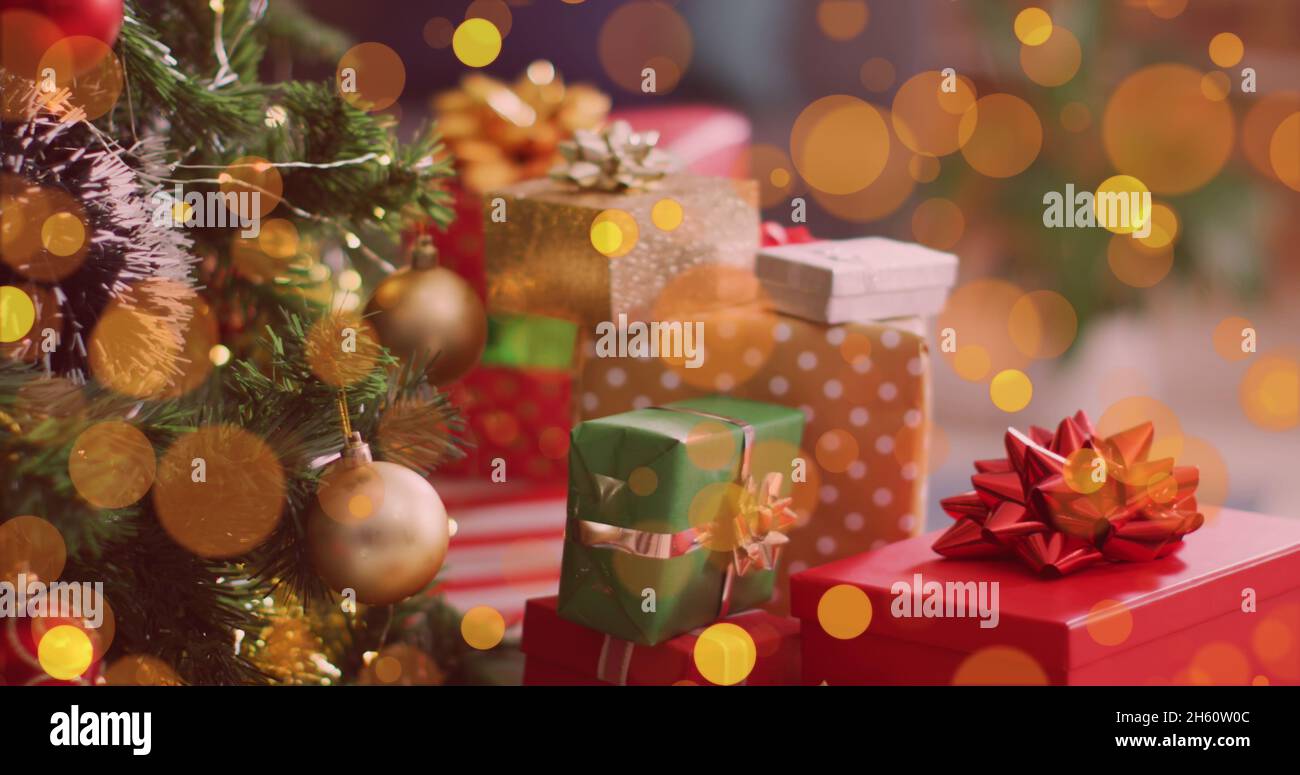 Image of golden dots stars falling over presents and christmas tree in ...