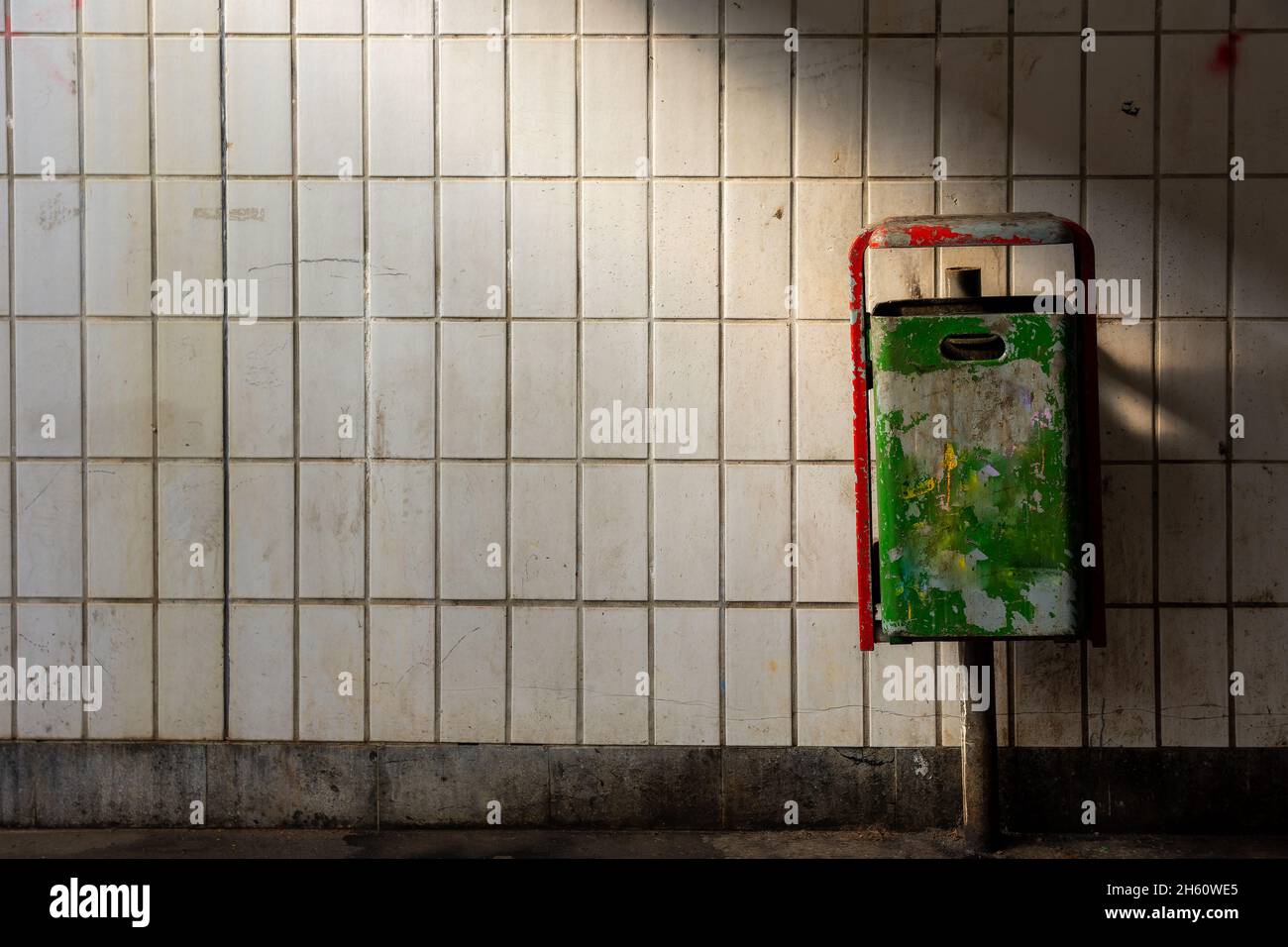Old metallic trash bin against a tiled wall Stock Photo - Alamy