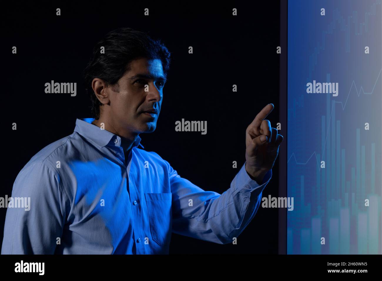 Man analysing sales data and growth graph chart on hologram screen ...