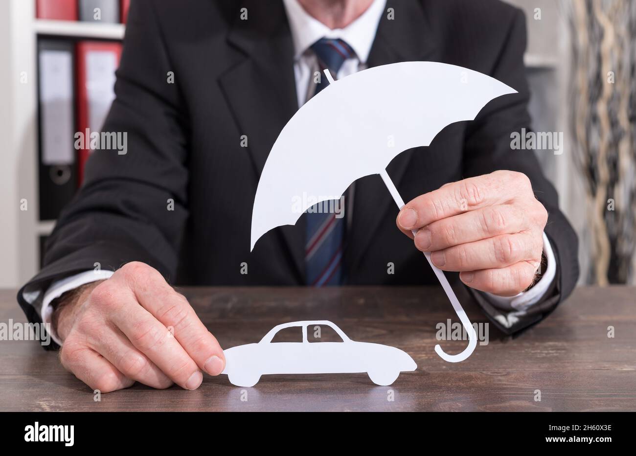 Car protected with an umbrella by an insurer - insurance concept Stock ...
