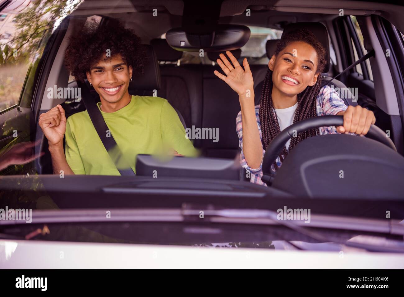Portrait of handsome beautiful cheerful couple driving car traveling ...