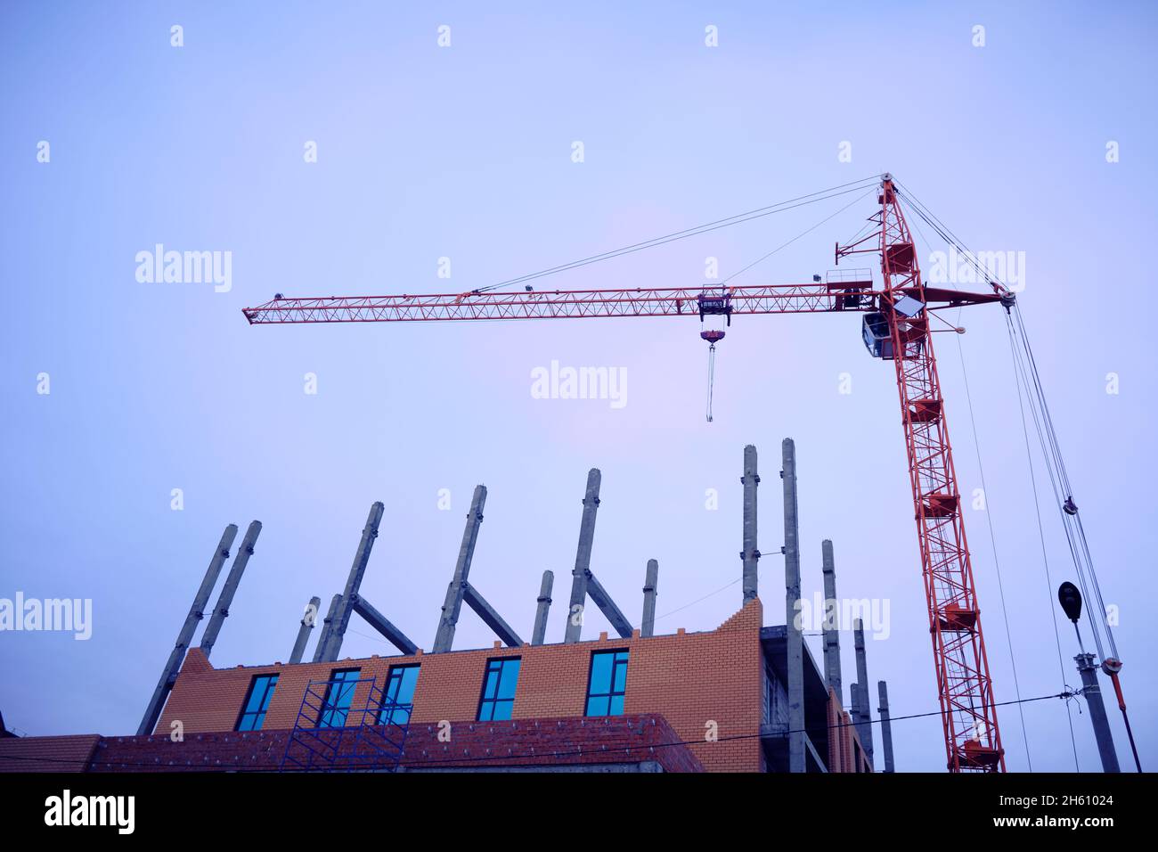High rise construction crane on background of an unfinished multi ...