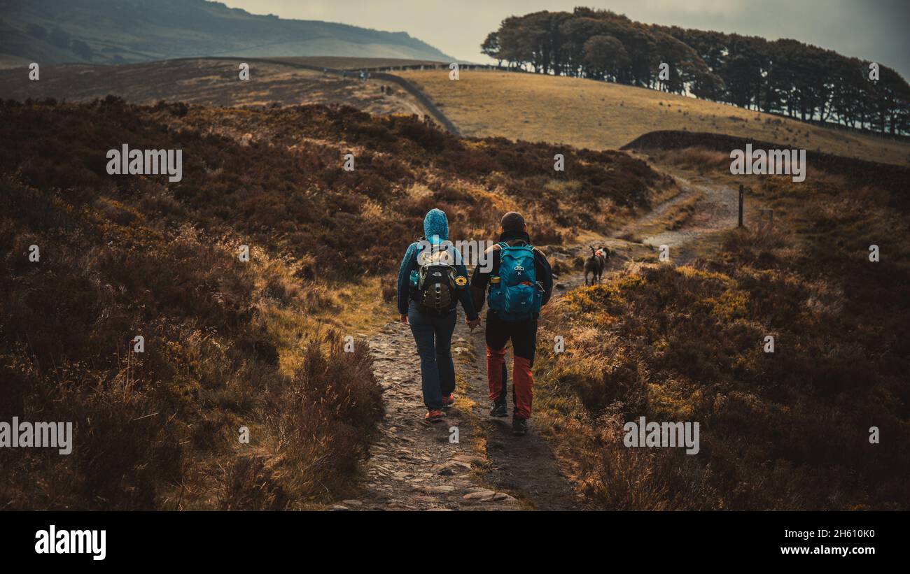 Hikers holding hands while walking along a narrow path Stock Photo - Alamy