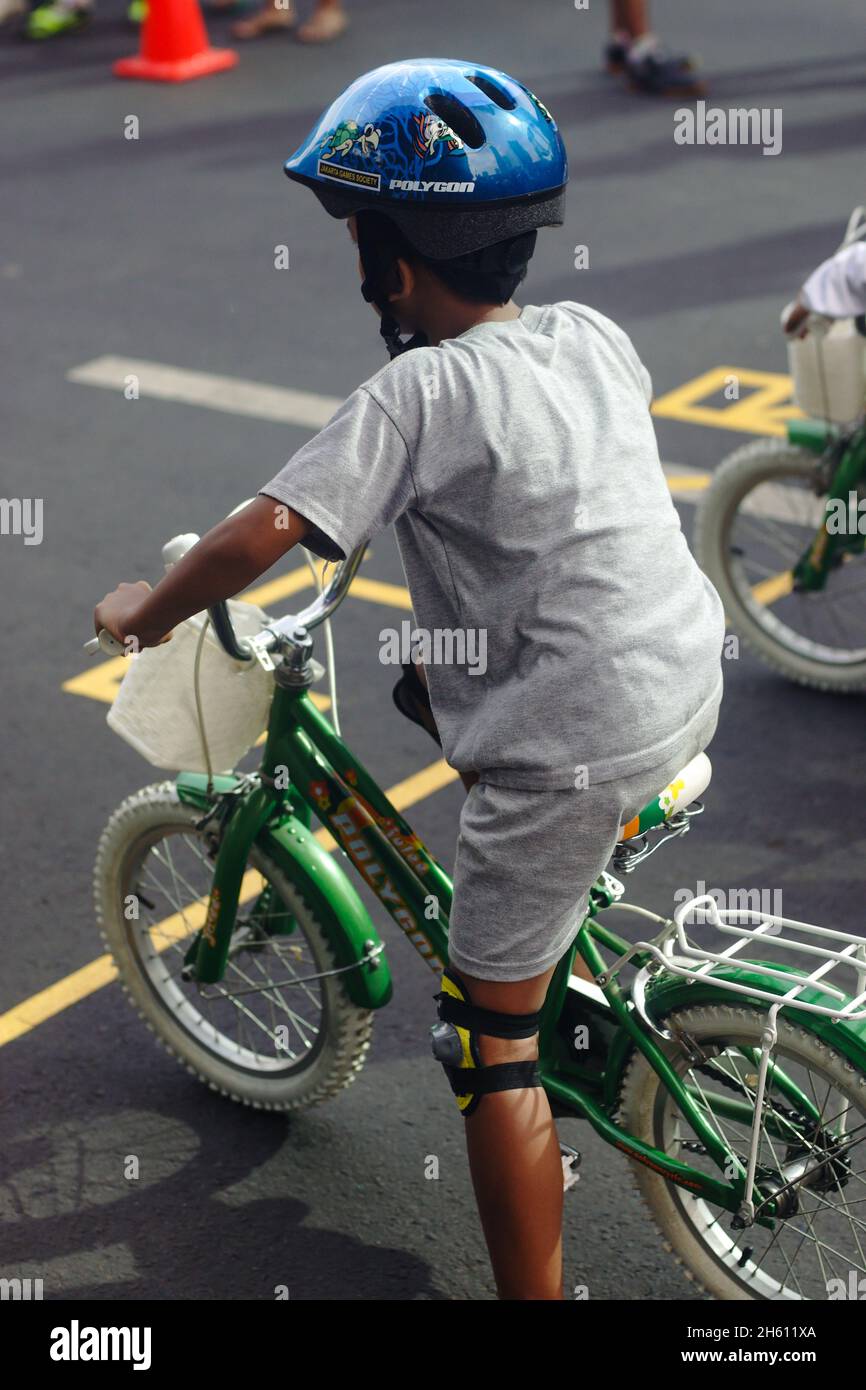 Portrait of young Asian boy from behind on bicycle race competition ...