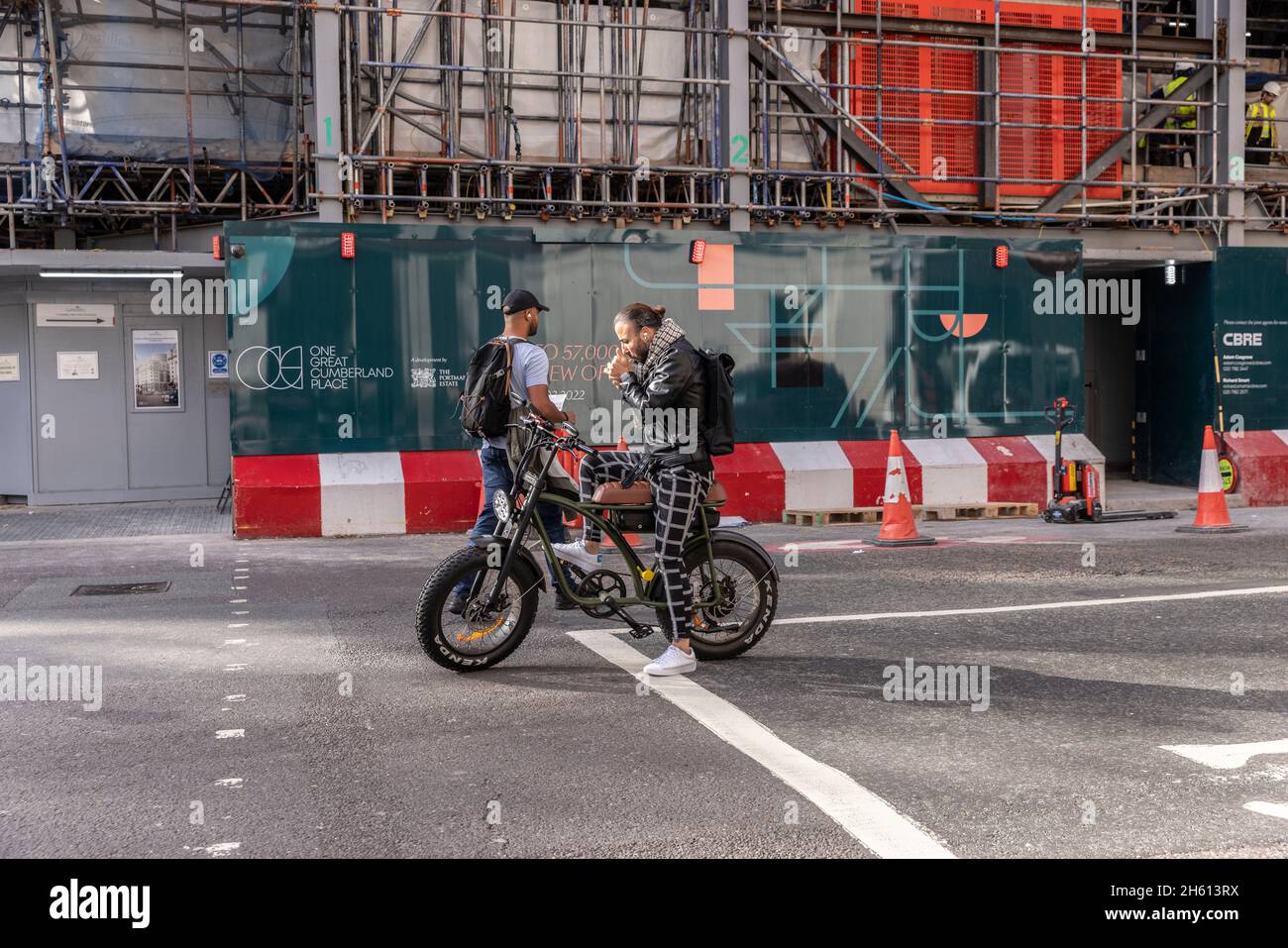 Cyclists without helmet wearing funky trousers on electric bike at ...