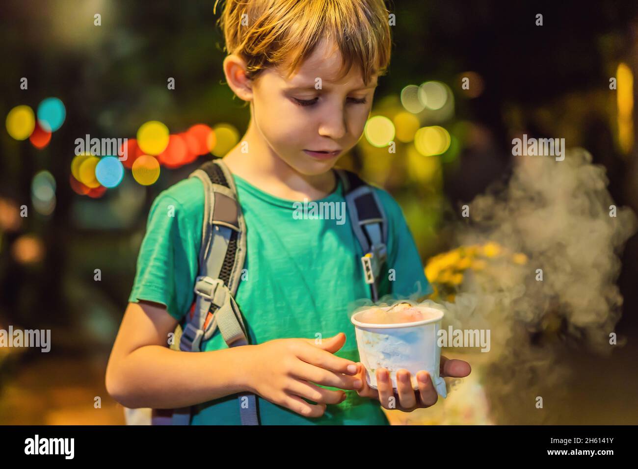 The boy is eating corn sticks spilled with liquid nitrogen Stock Photo ...