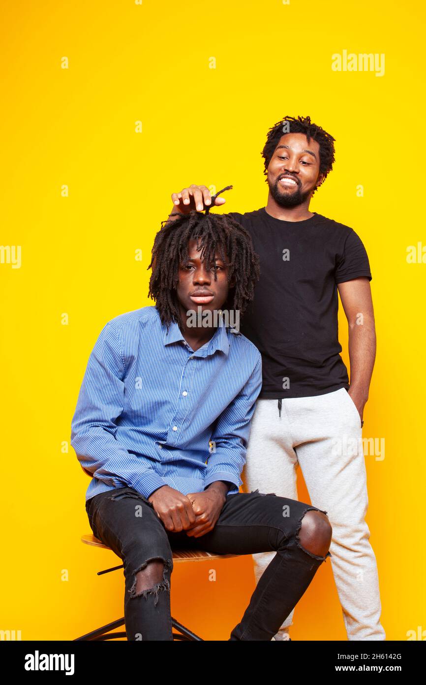 two african american guys posing cheerful together on yellow background ...