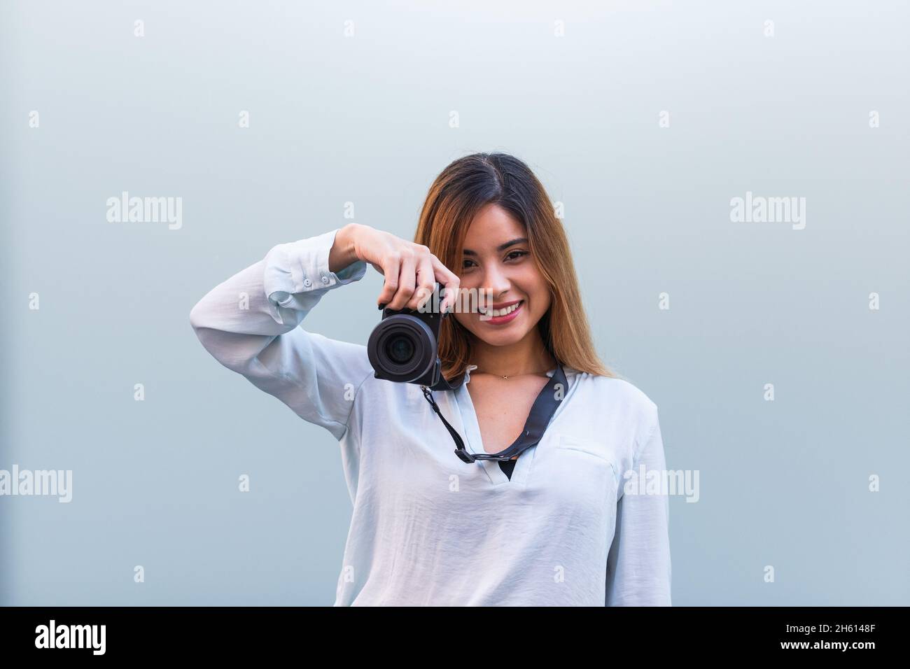 Close up of photographer smiling at camera while taking photo with ...