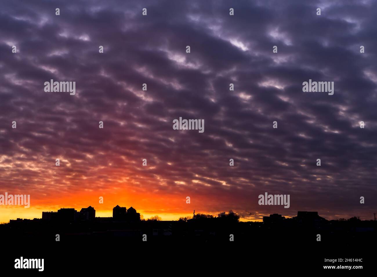 Amazing colorful sunset with lilac clouds and city silhouette. Naturel ...