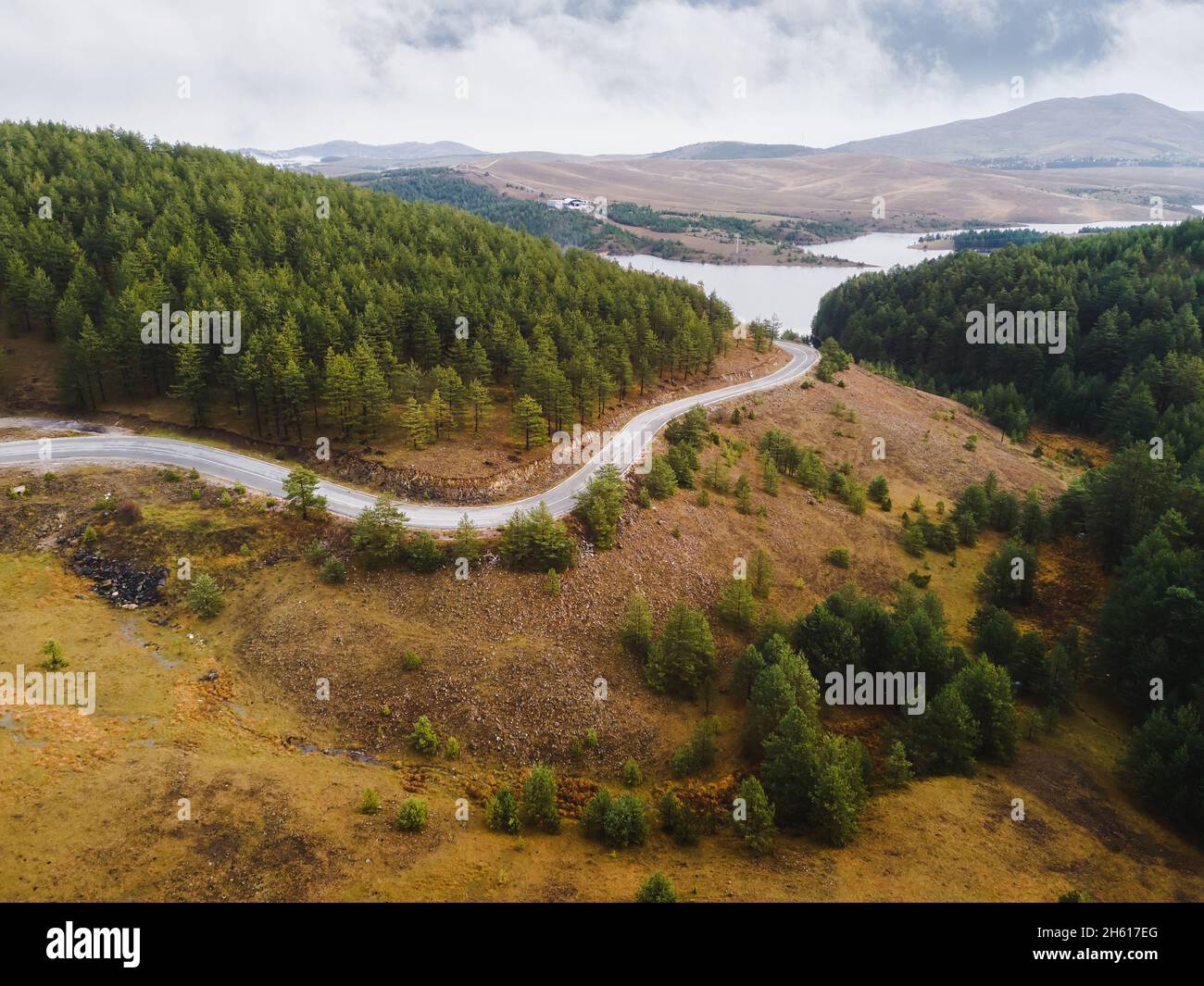 Aerial view of mountain landscape with road and lake in beautiful foggy ...