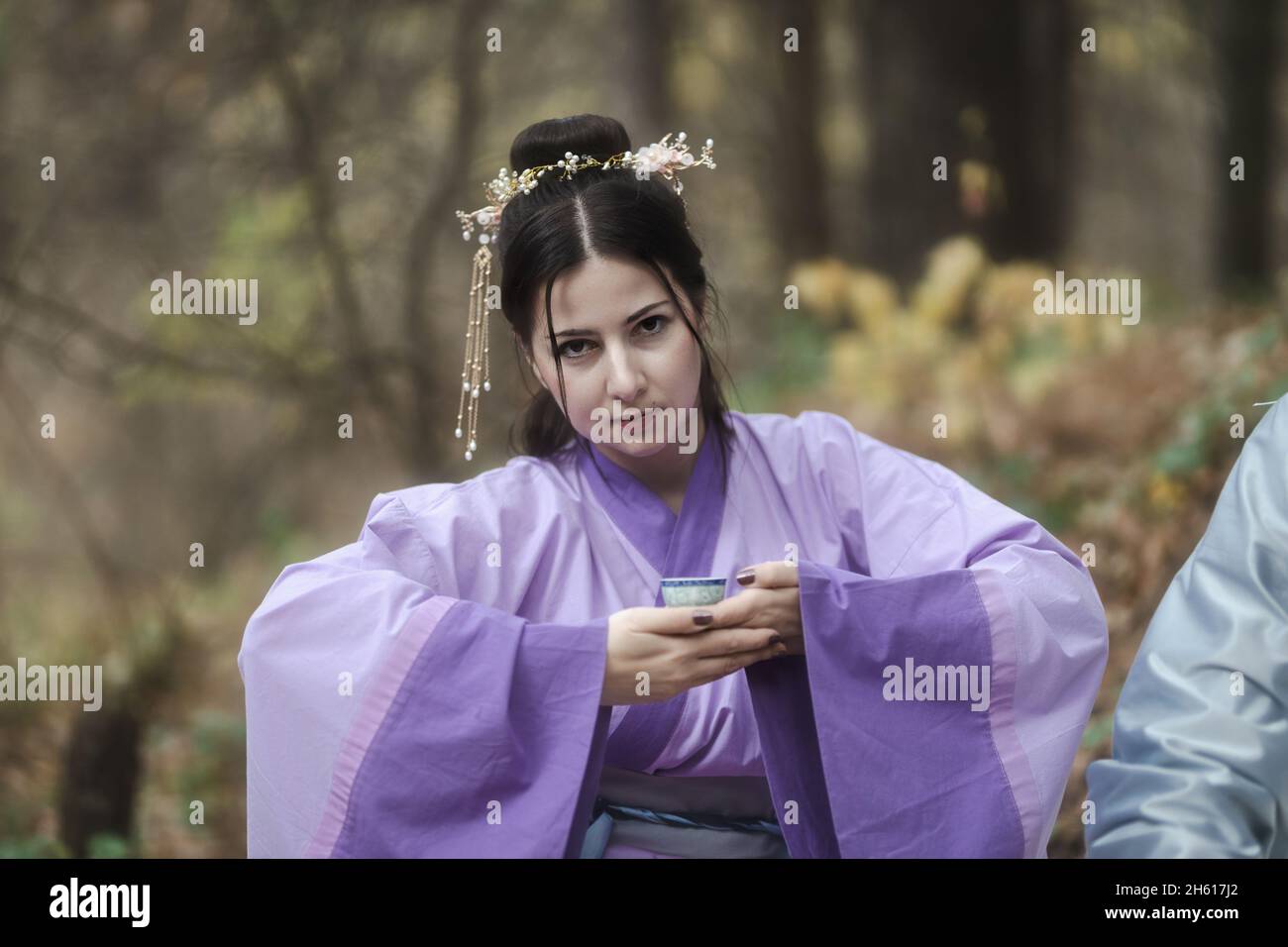 A non-Chinese woman posing against the backdrop of an autumn forest ...
