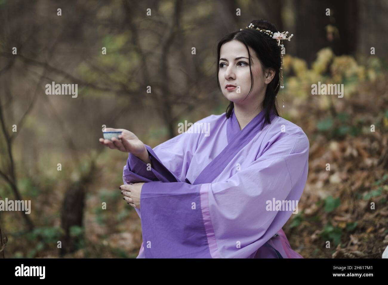 A non-Chinese woman posing against the backdrop of an autumn forest ...
