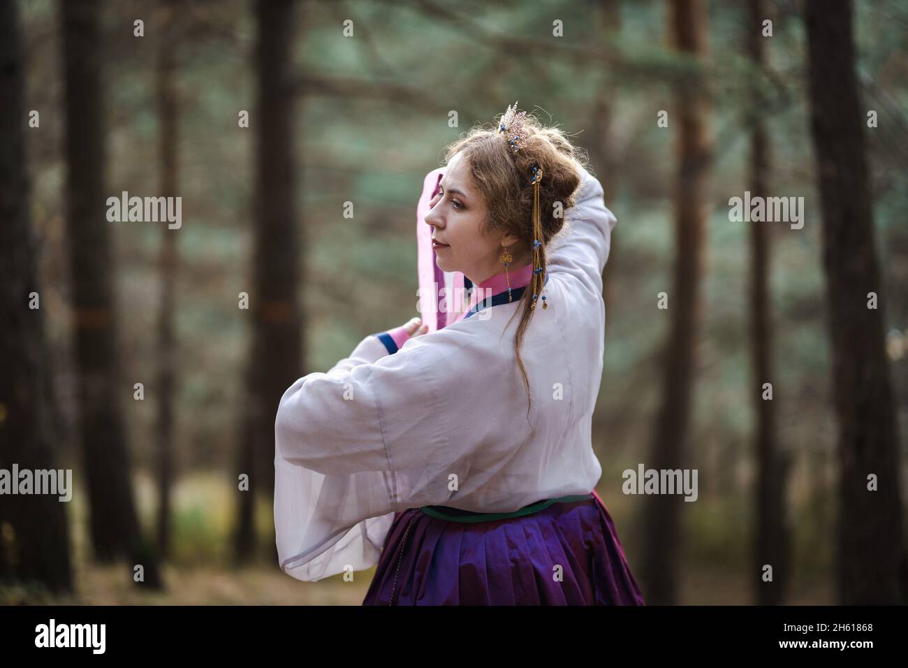 A non-Chinese woman posing against the backdrop of an autumn forest ...
