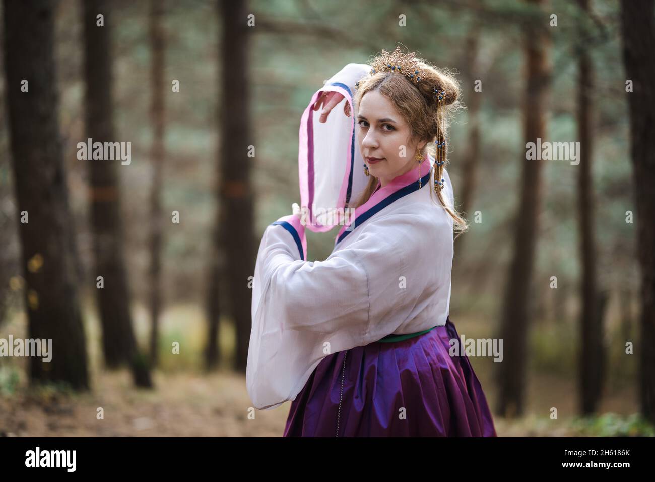 A non-Chinese woman posing against the backdrop of an autumn forest ...