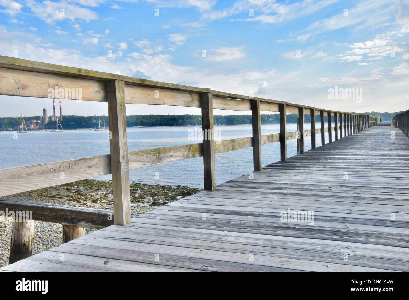 A long wooden dock stretches toward the horizon. Copy space. Port ...