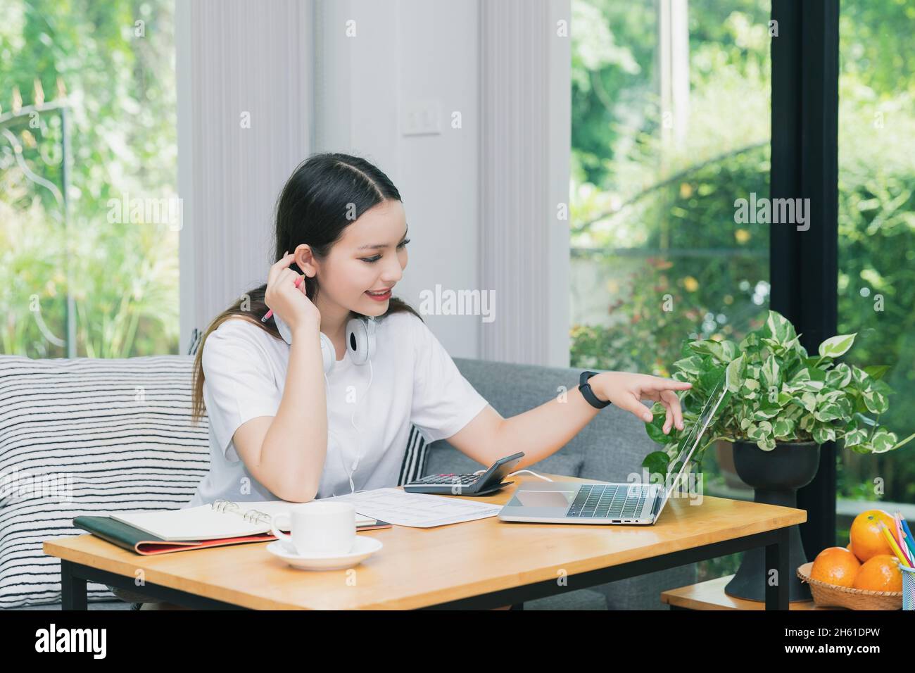 Young student watching lesson online and studying from home. She using ...