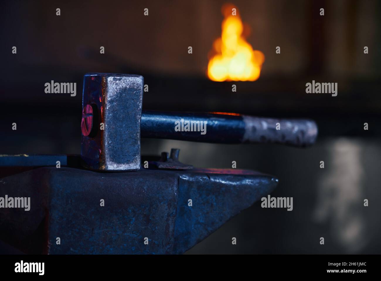 Close up of heavy hammer lying on anvil at forge with blur background ...