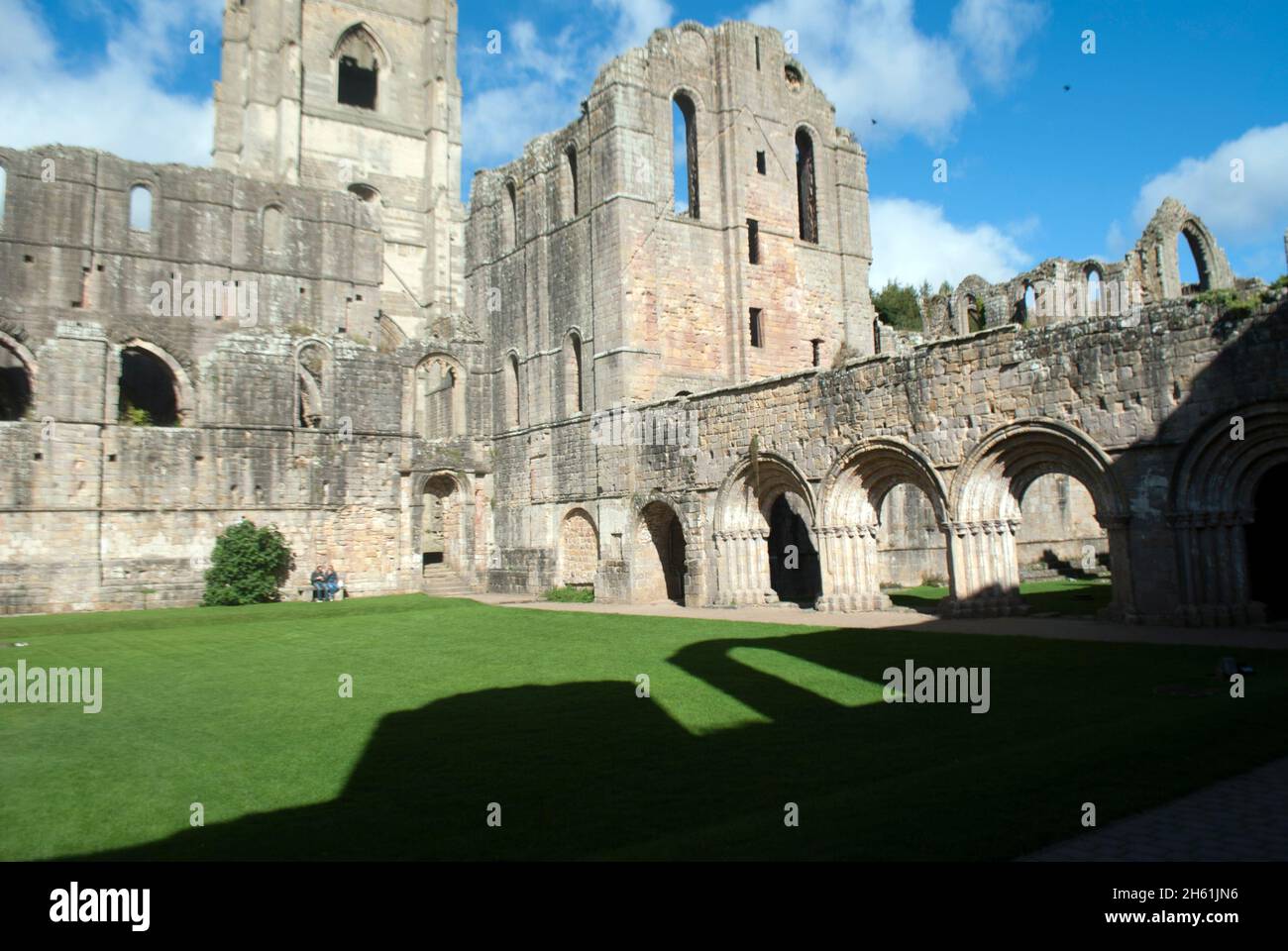 Two people sitting in Cloister Court at Fountains Abbey, Aldfield, near ...