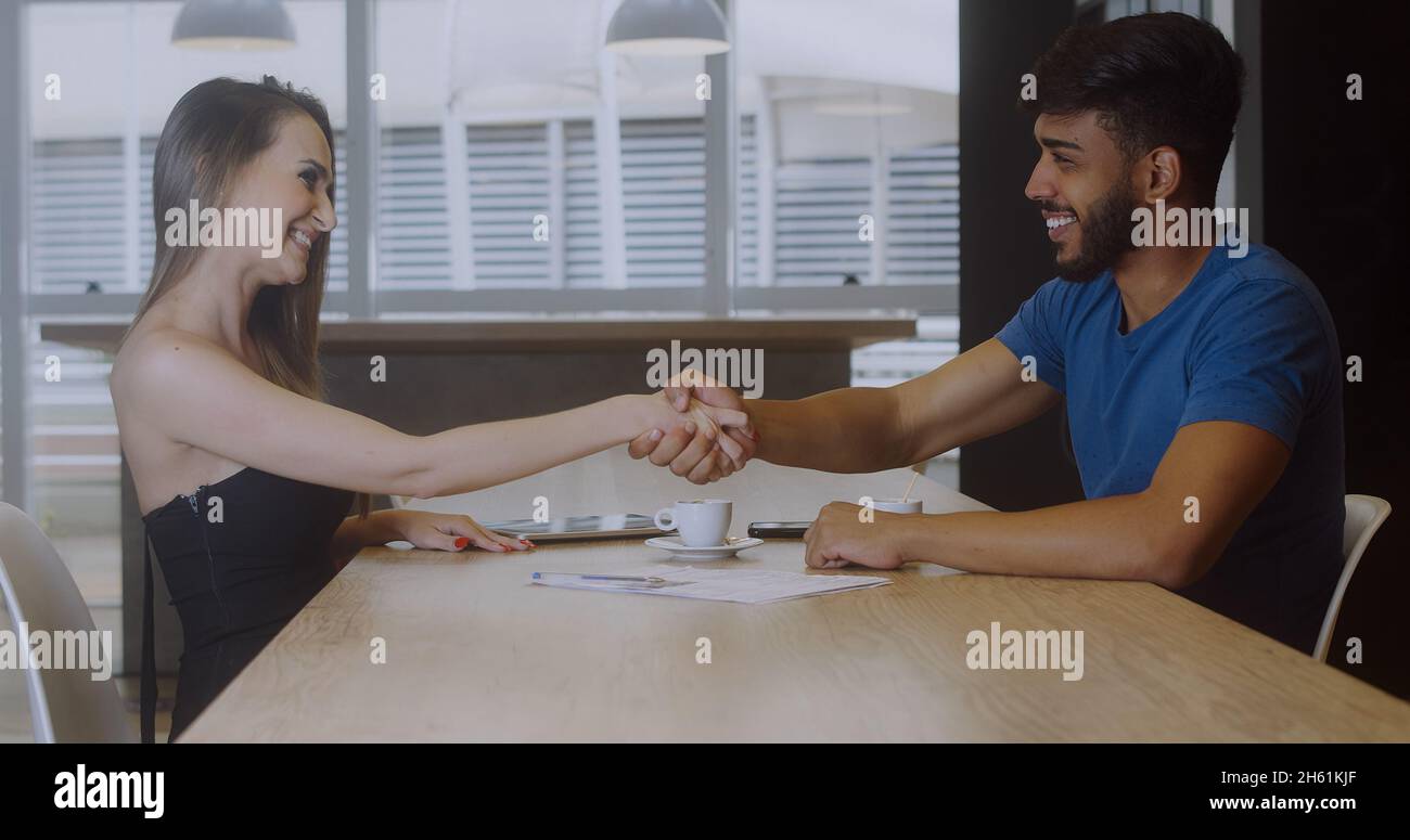 Young male HR manager handshaking welcoming hired employee got new job ...