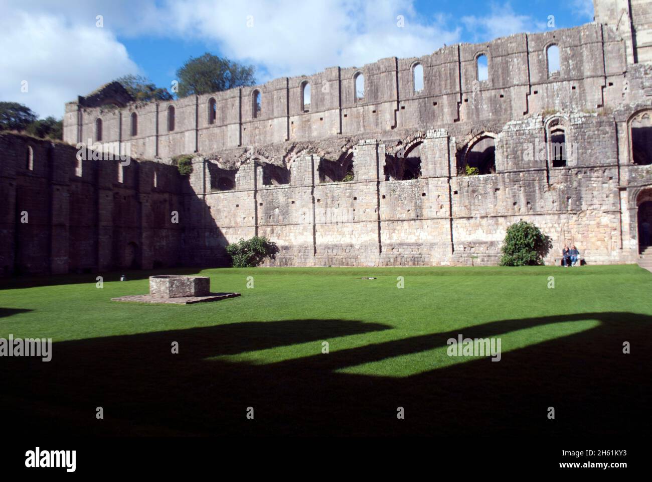 Two people sitting in Cloister Court at Fountains Abbey, Aldfield, near ...
