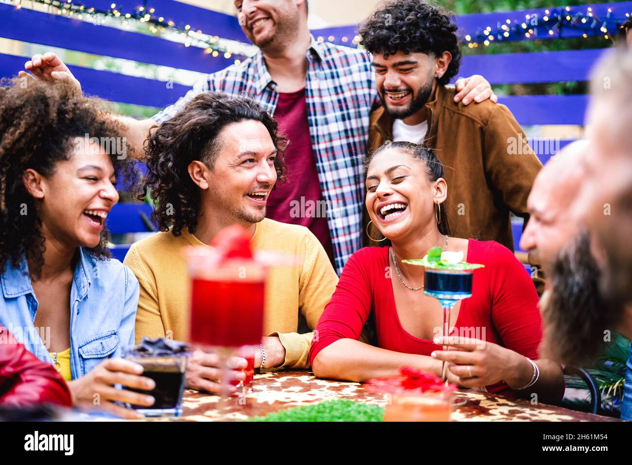Multicultural people having genuine fun moment at fancy cocktail bar ...