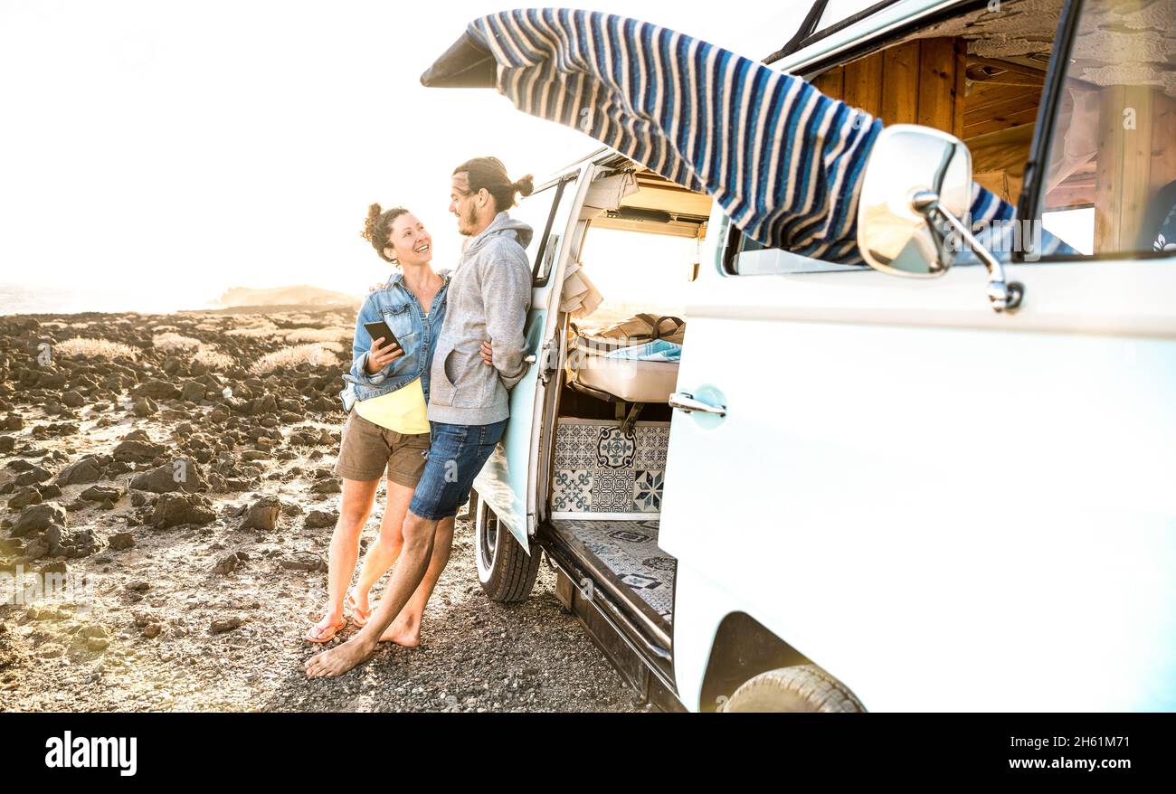 Young hipster couple at relax moment together by oldtimer mini van ...