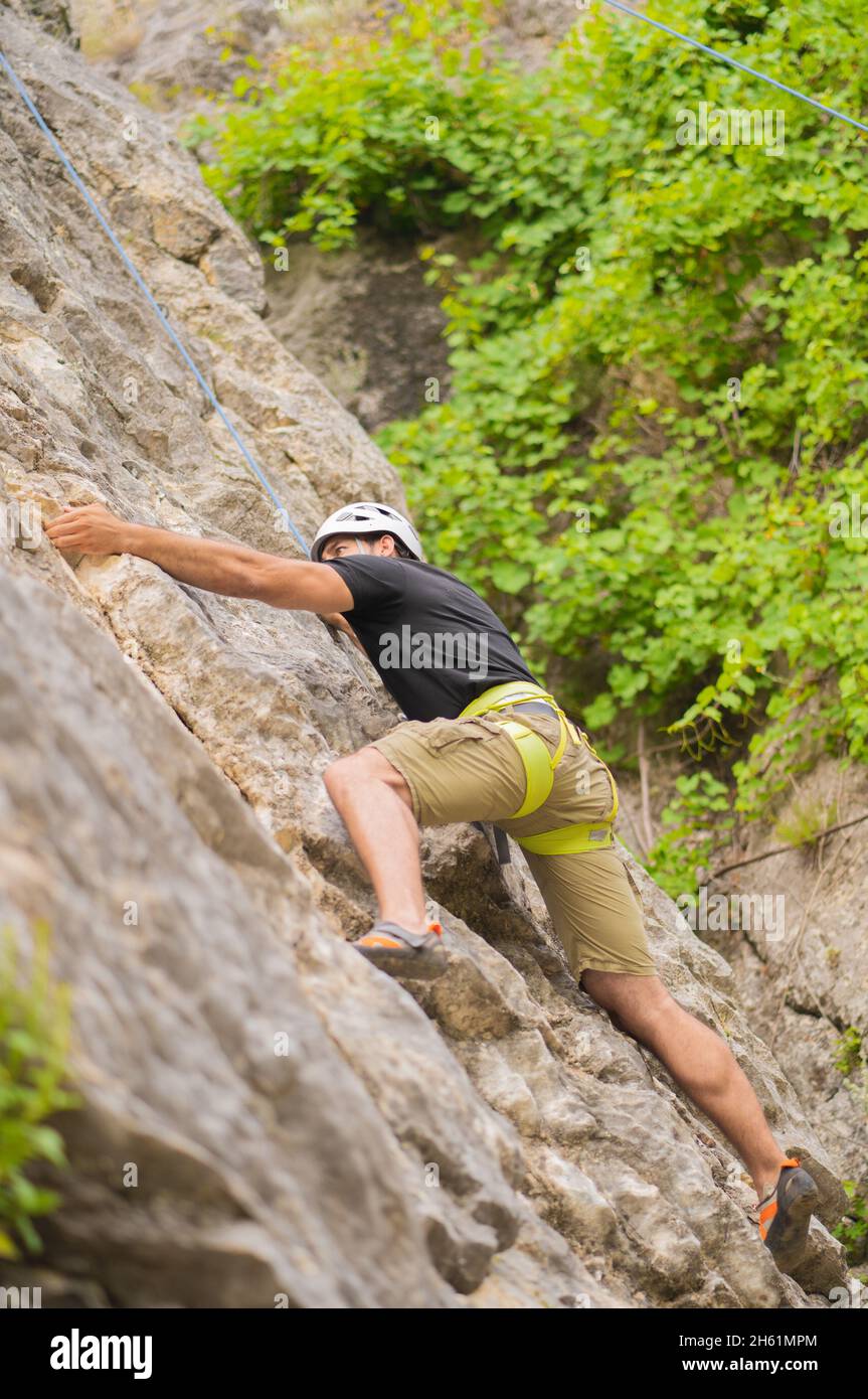 Fit and handsome guy is climbing ht emountain hill while thinking of ...