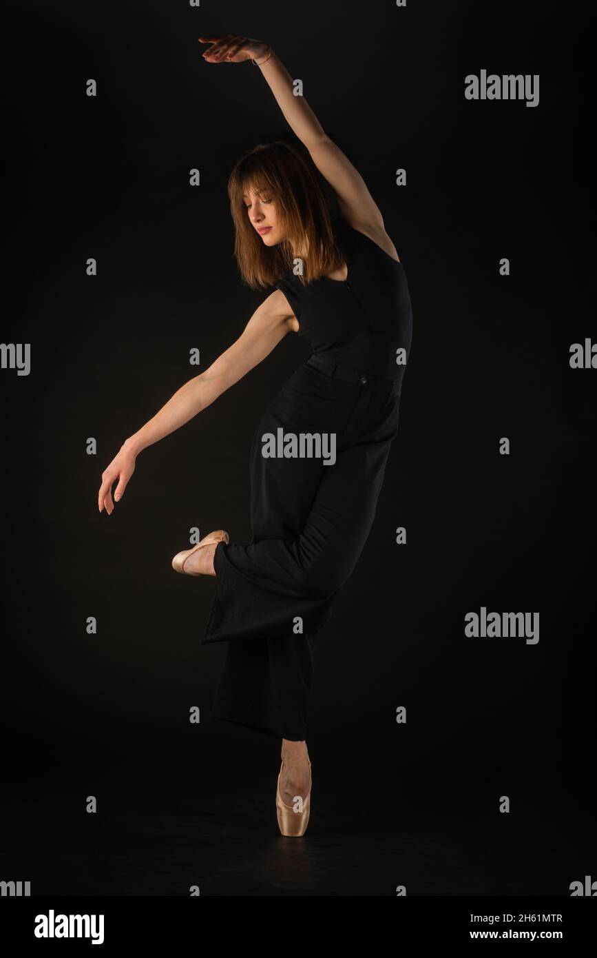 Beautiful ballerina is doing a perfect asymmetrical pose while ...