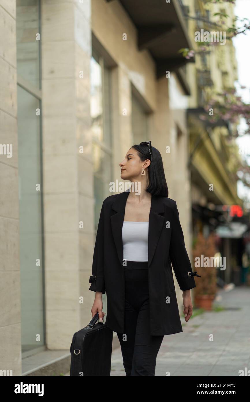 Attractive businesswoman is walking towards the company while thinking ...