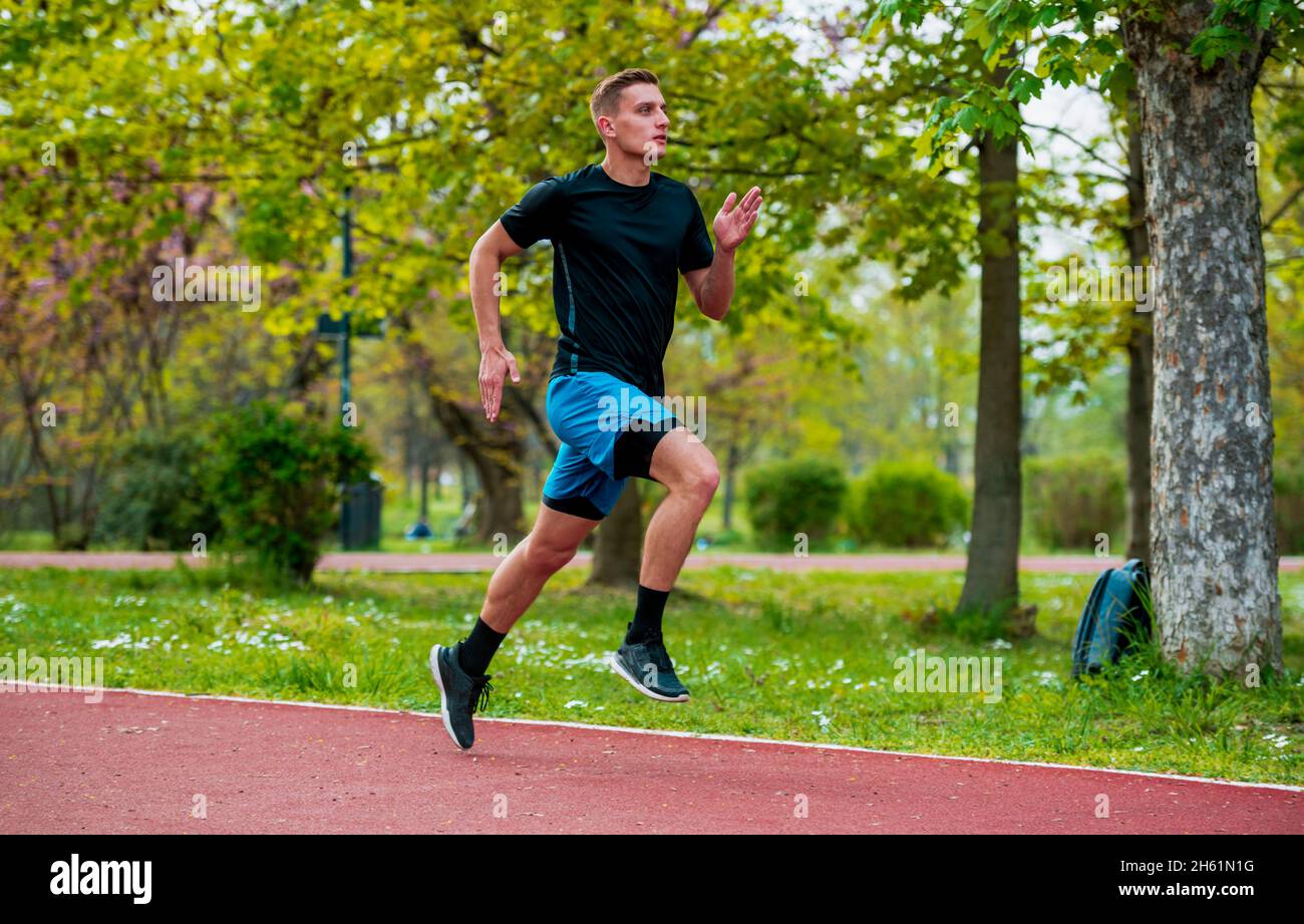 Handsome young Caucasian man running, exercising in the morning at a ...