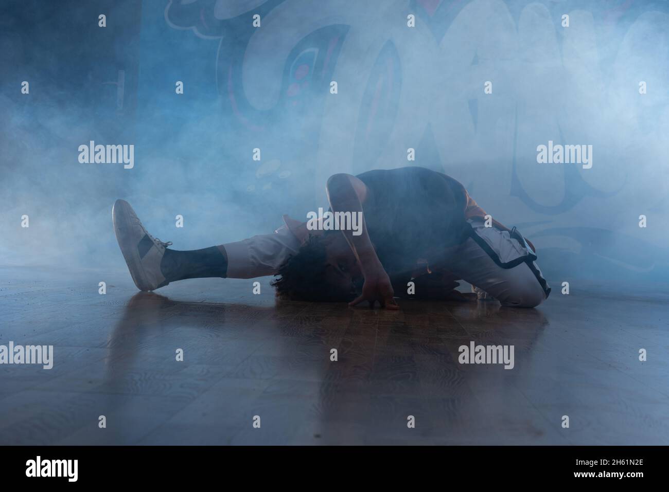 Young man break dancing in club with lights and smoke Stock Photo - Alamy