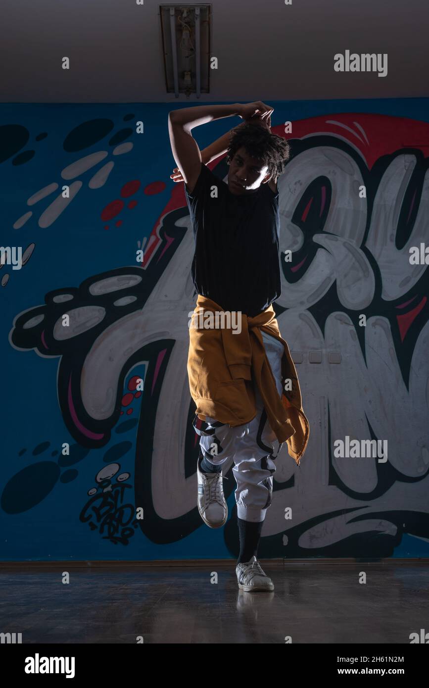 African American hip hop dancer (breakdancer) performing over graffiti ...