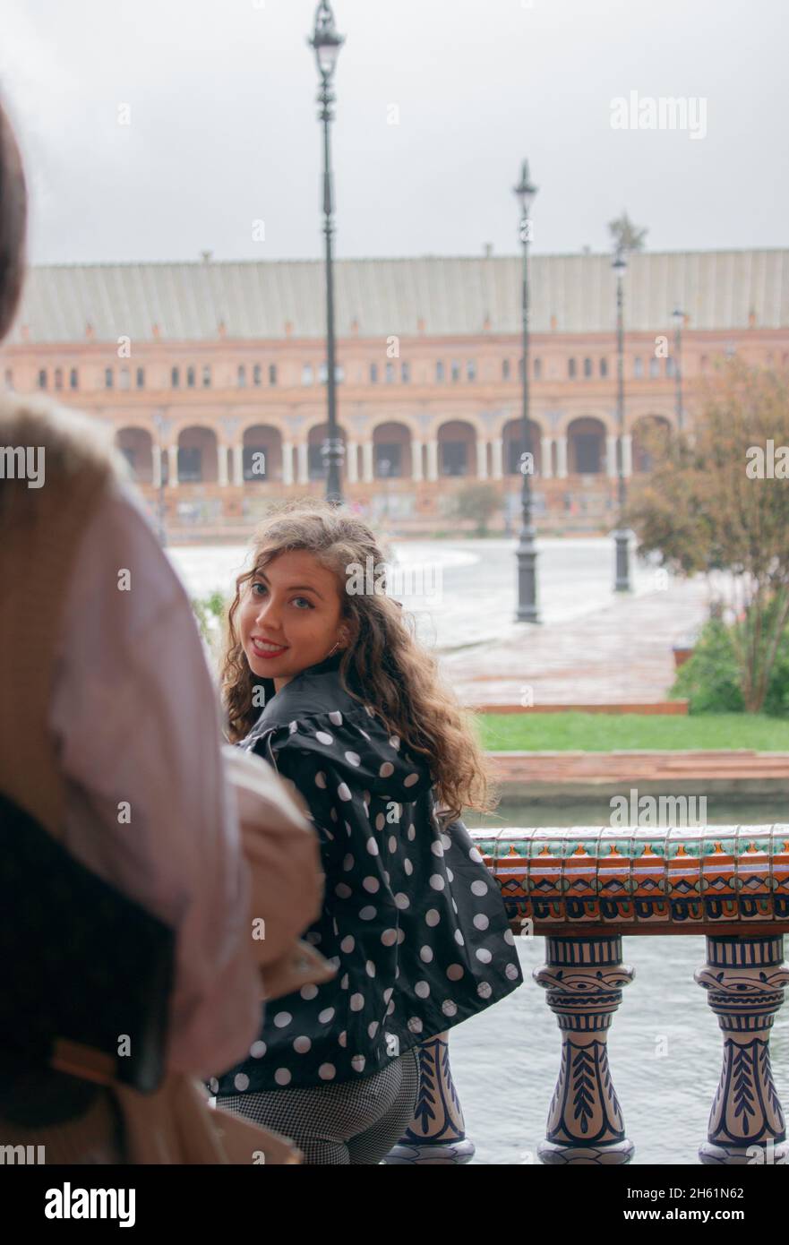 Young girl poses smiling while her friend takes a picture of her in ...