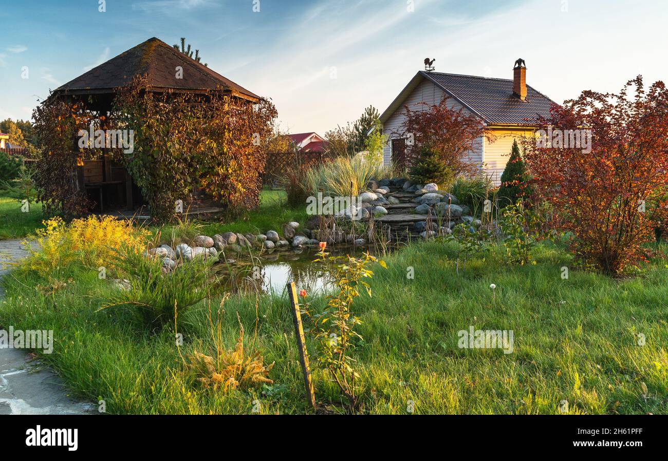landscape with Garden pond and small country cabin in countryside ...