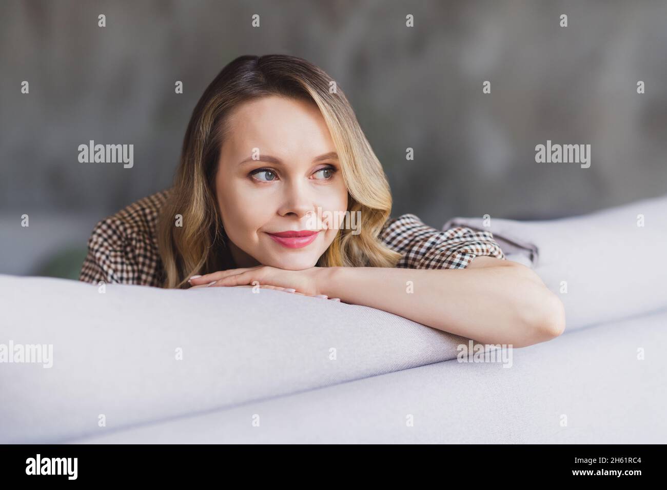 Portrait of attractive dreamy girl resting sitting on divan waiting ...