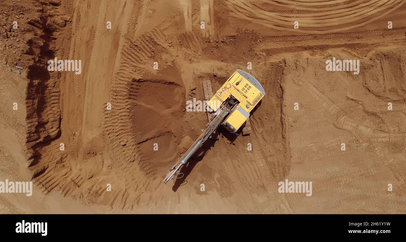 Aerial view of a digger, tracked excavator at work on a construction ...