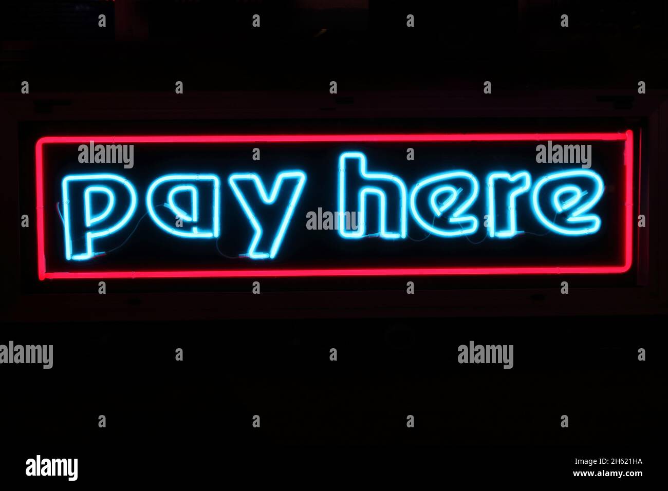 Neon Pay Here sign Stock Photo - Alamy