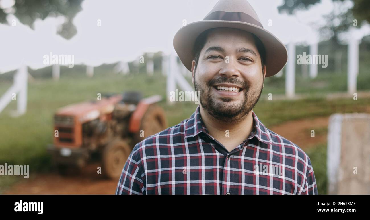 Portrait of young Latin farmer man in the casual shirt in the farm on ...